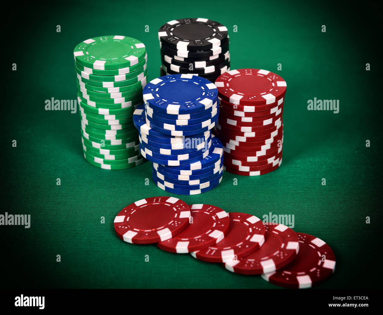 Color stacks of poker chips in green table Stock Photo - Alamy