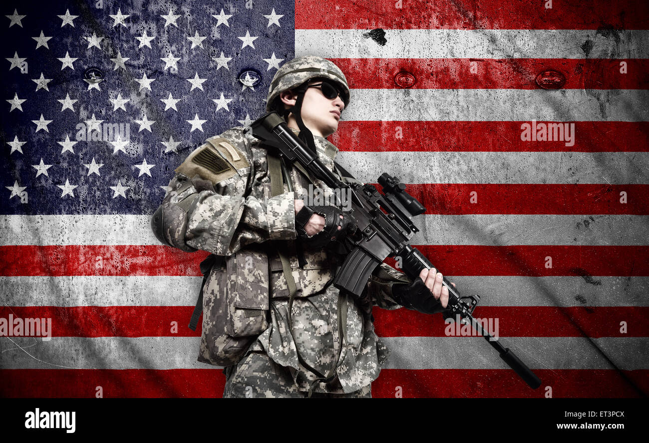 soldier holding rifle on a american flag background Stock Photo - Alamy