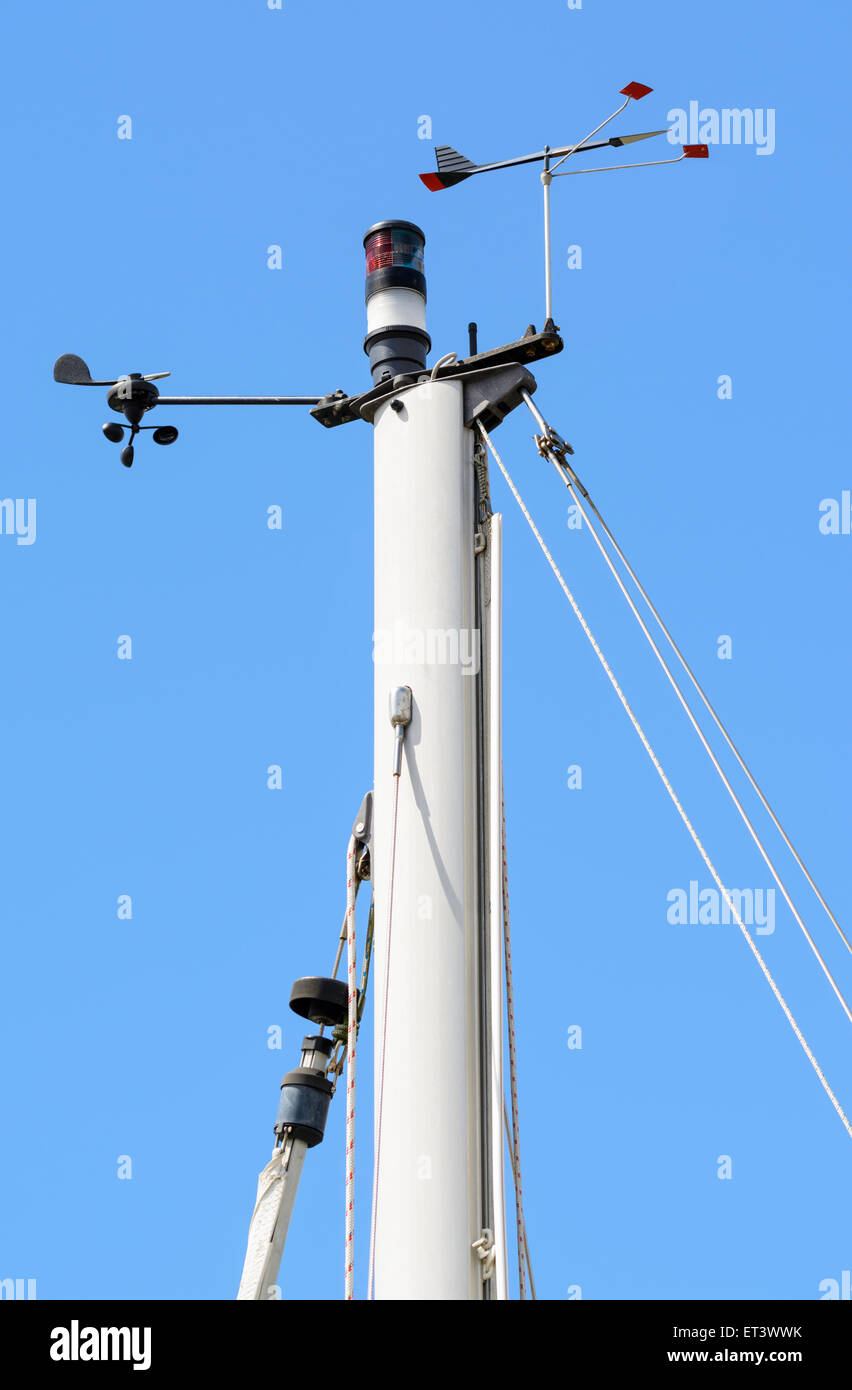 Yacht mast with weather related instruments and red navigation light ...