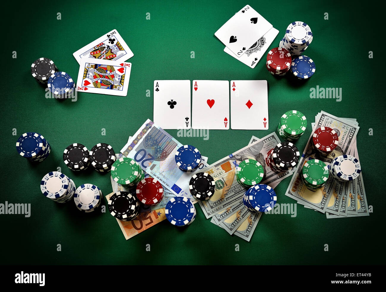 Stack of chips, three aces and money on green table Stock Photo - Alamy