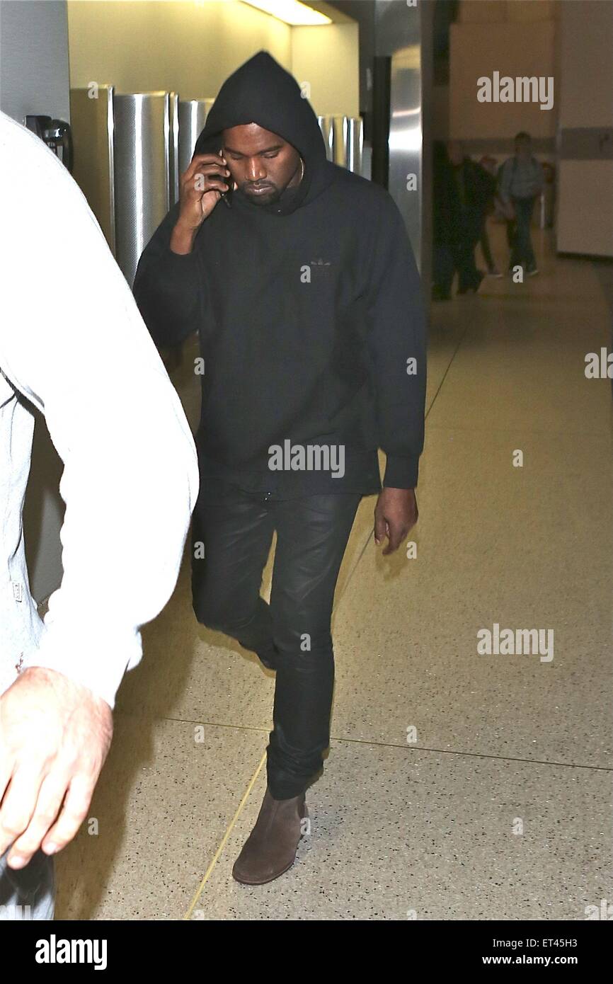 Kanye West talking on his cellphone as he leaves on a flight from Los ...