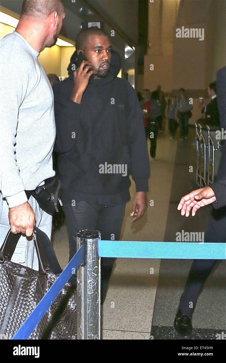 Kanye West talking on his cellphone as he leaves on a flight from Los ...