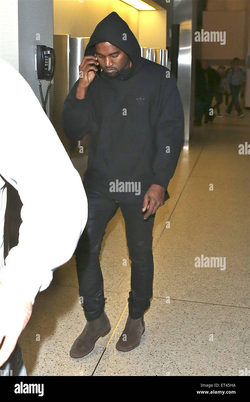 Kanye West talking on his cellphone as he leaves on a flight from Los ...