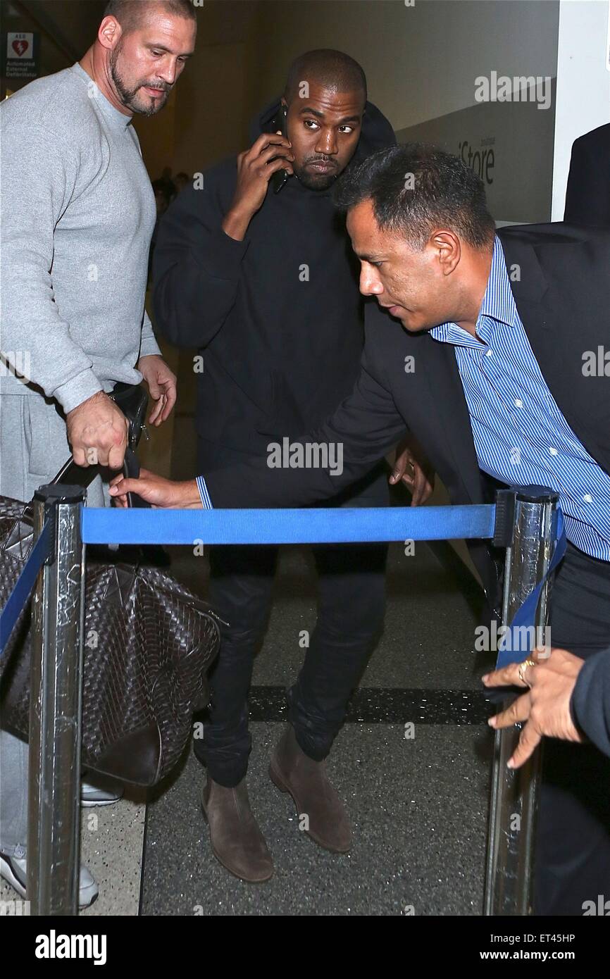 Kanye West talking on his cellphone as he leaves on a flight from Los ...