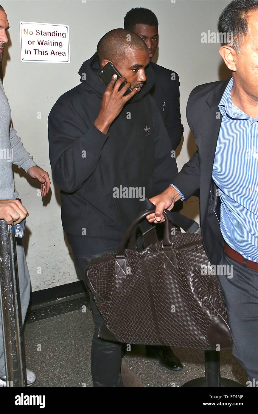 Kanye West talking on his cellphone as he leaves on a flight from Los ...