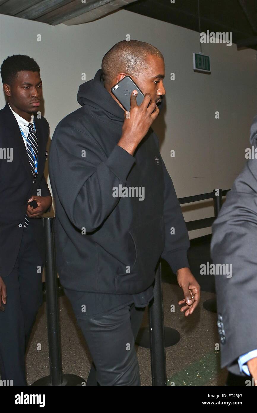 Kanye West talking on his cellphone as he leaves on a flight from Los ...