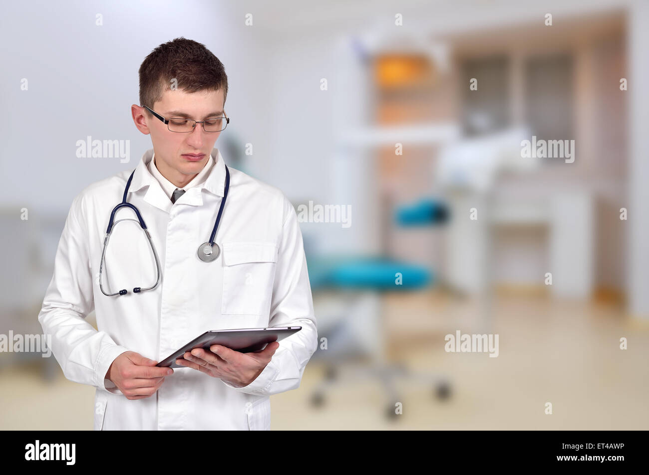 Young doctor with touch pad standing in clinic Stock Photo - Alamy