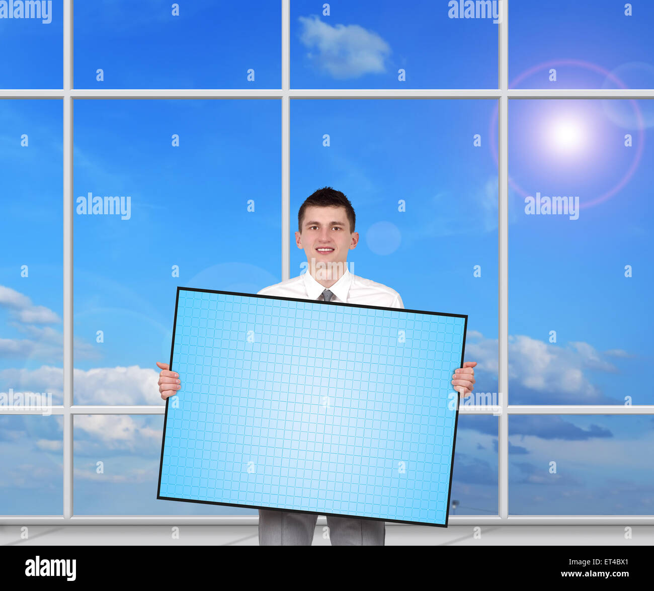 businessman holding blank plasma panel on big window background Stock ...
