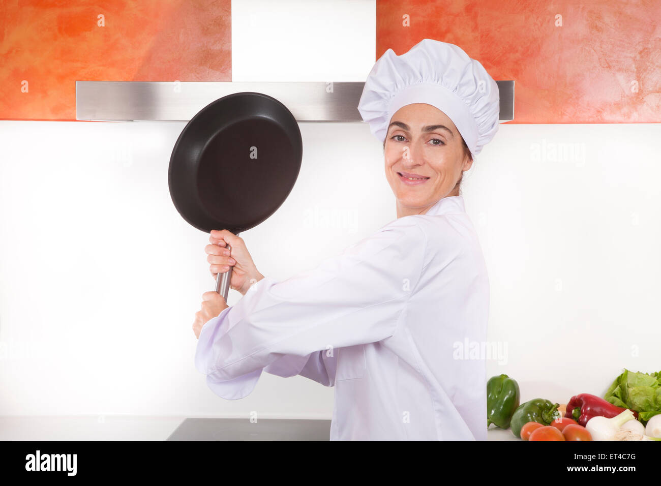 portrait of happy brunette chef woman with professional jacket and hat ...