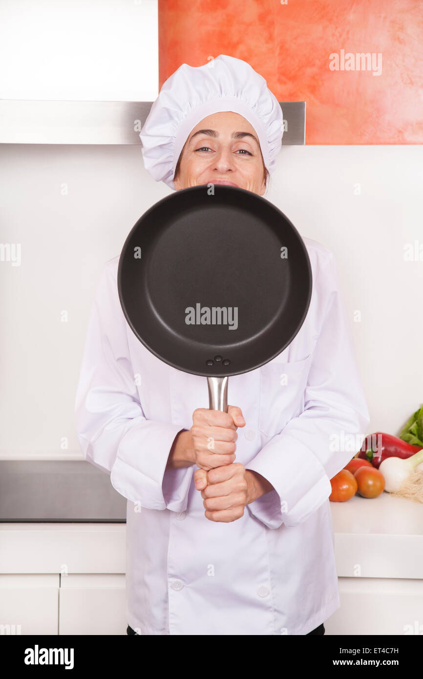 portrait of happy brunette chef woman with professional jacket and hat ...