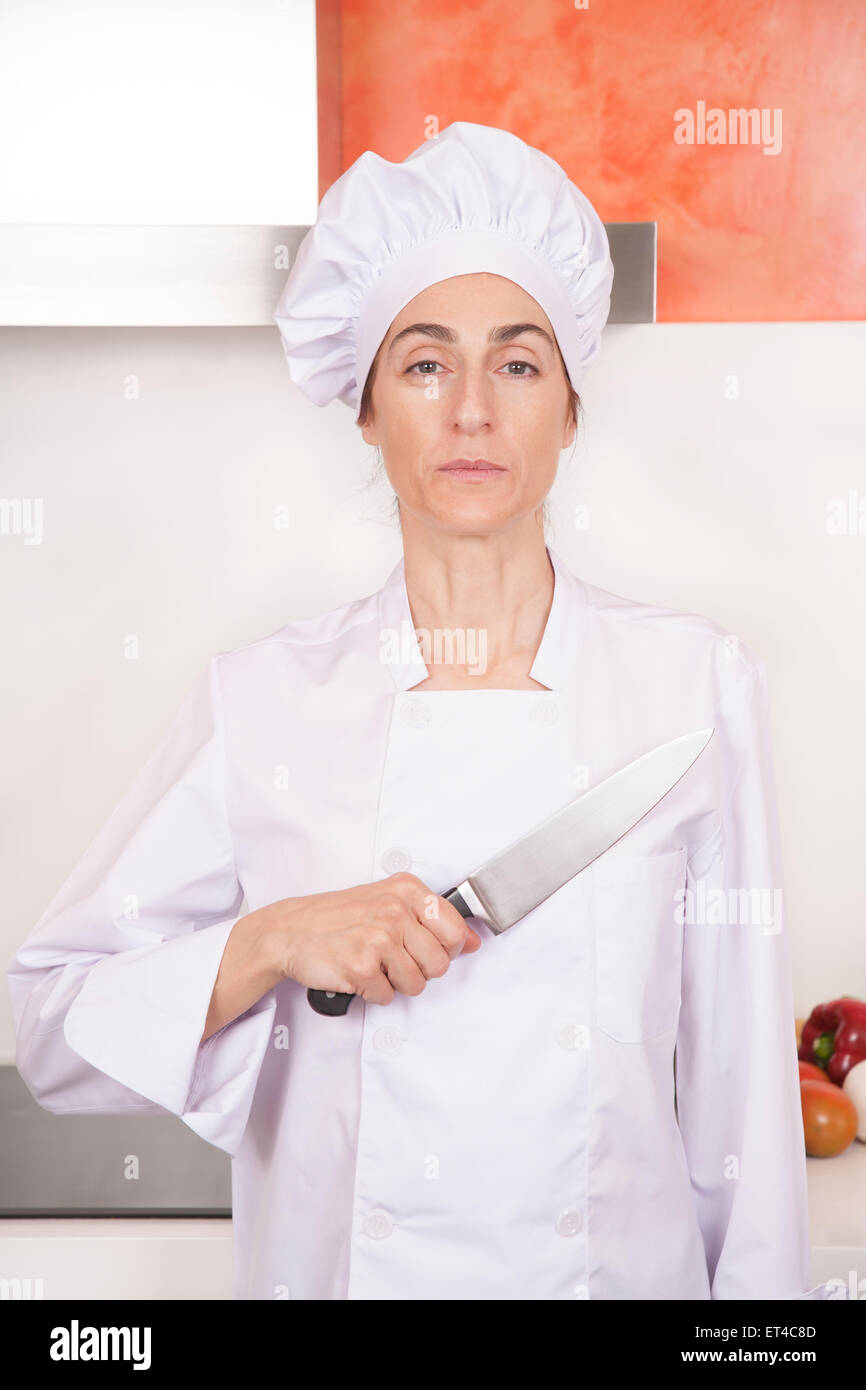 portrait of serious brunette chef woman with professional jacket and ...