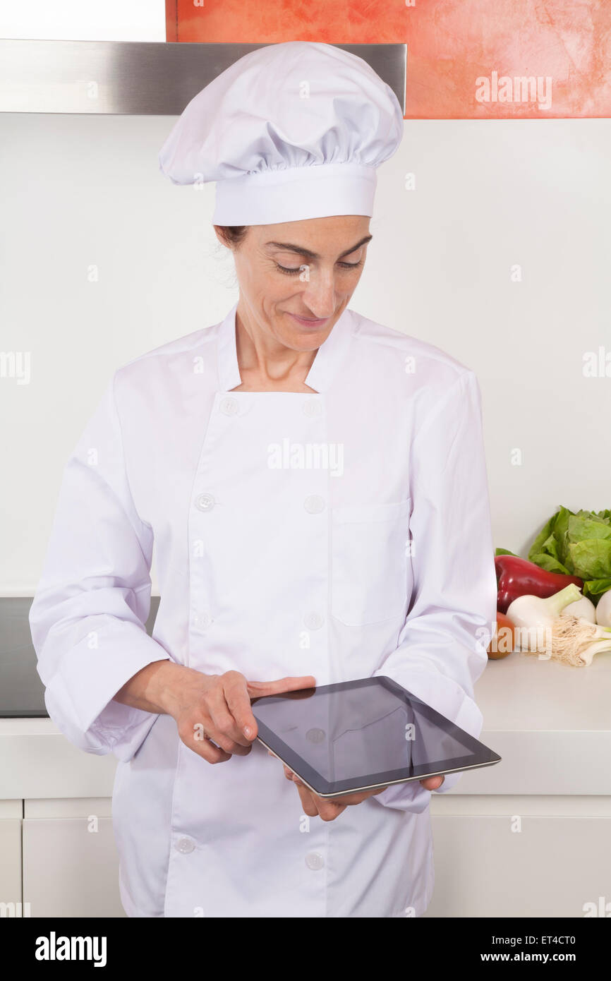 portrait of brunette happy chef woman with professional jacket and hat ...
