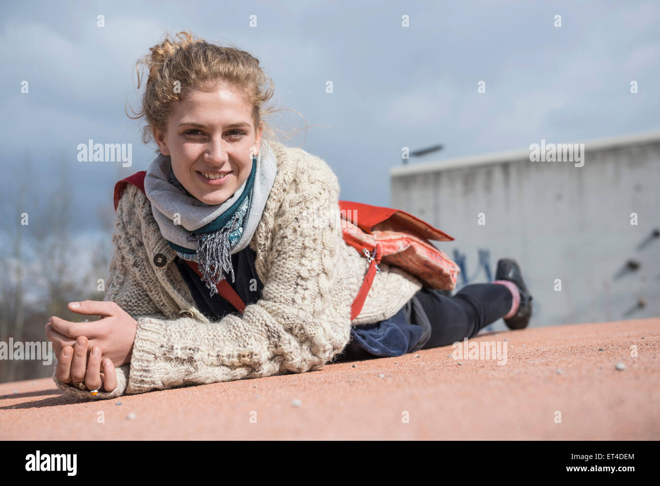 Portrait of a young woman lying on roundabout and smiling Munich ...