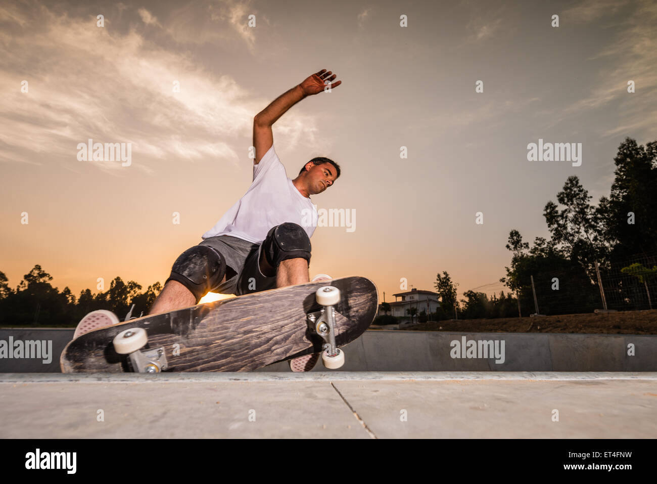 Skateboarder in a concrete pool at skatepark on a beatiful sunset Stock ...