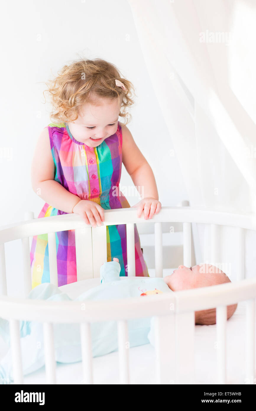 Kids in bed. Two children playing together in a white sunny bedroom ...