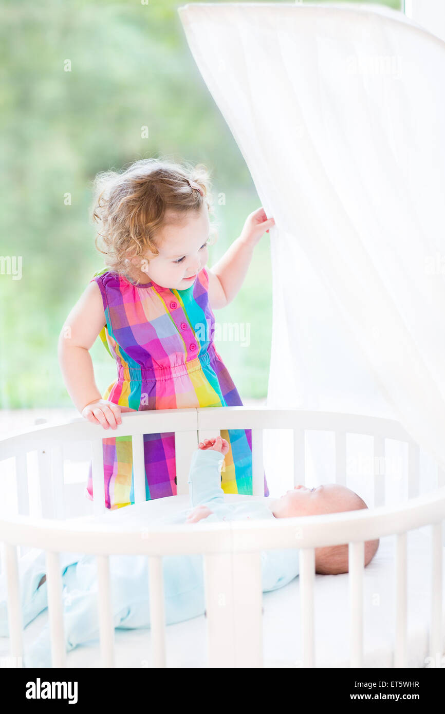 Kids in bed. Two children playing together in a white sunny bedroom ...