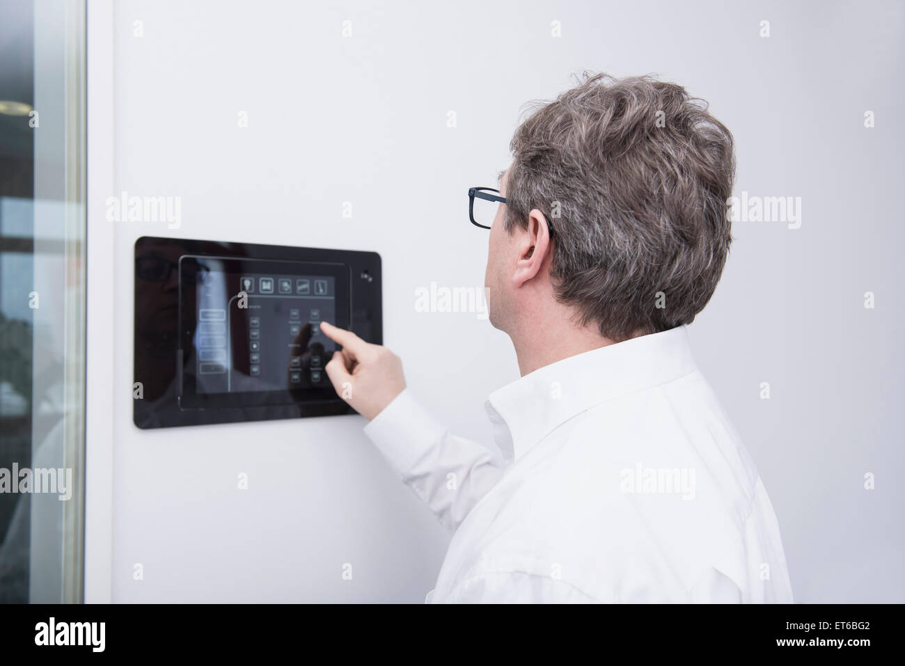 Man operating control panel on wall mounted, Munich, Bavaria, Germany ...