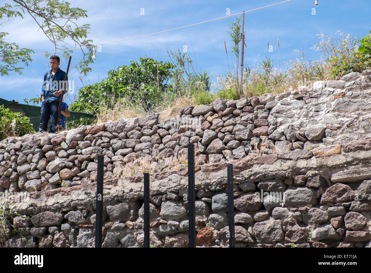 Young Syrian refugee looks out over the harbor of Molyvos, Greece where ...