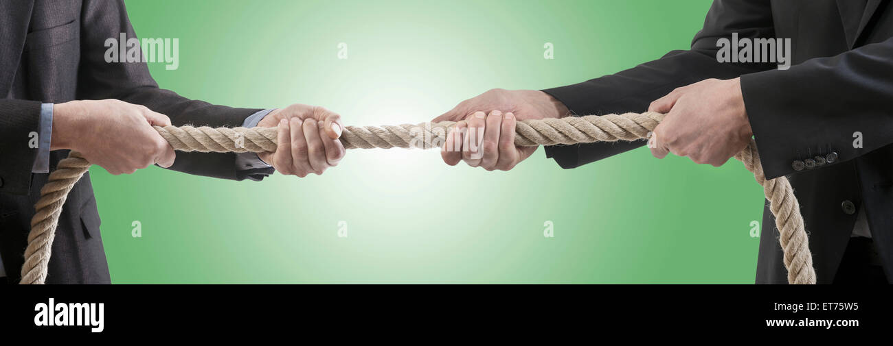 Mid section view of two businessmen pulling rope, Bavaria, Germany ...