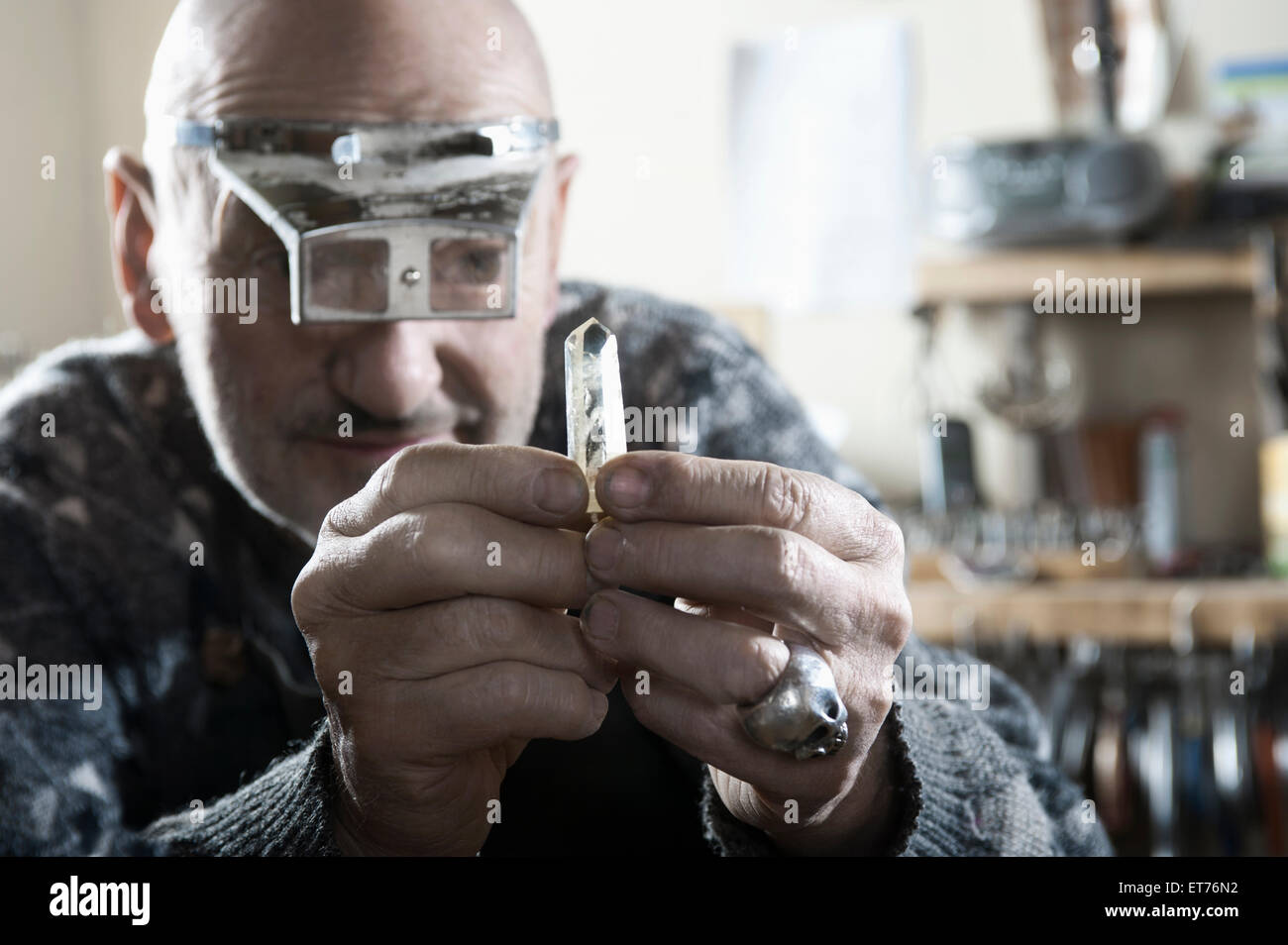Senior male goldsmith looking at crystal, Bavaria, Germany Stock Photo ...