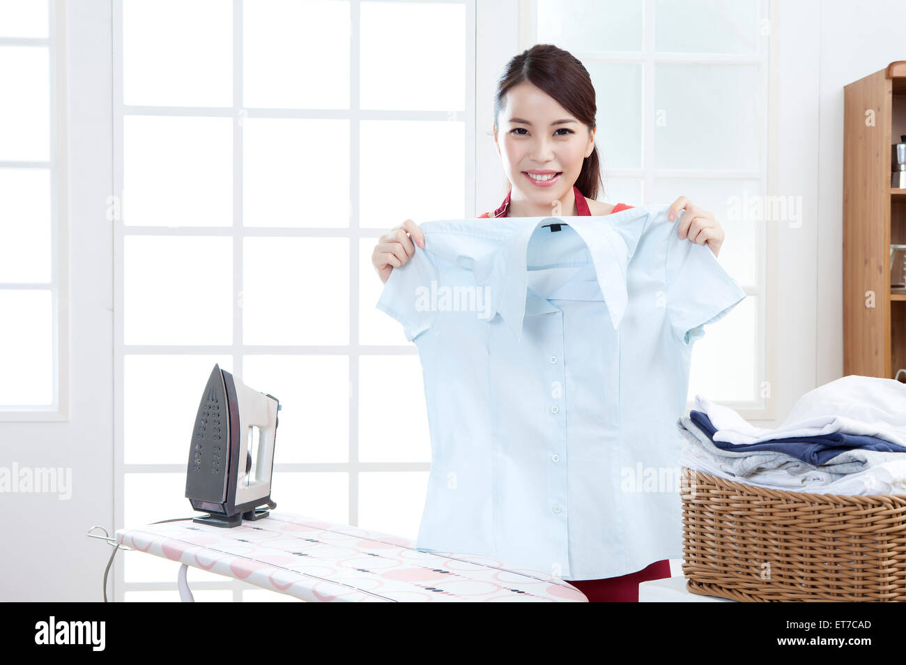 Woman holding up clothes hi-res stock photography and images - Alamy