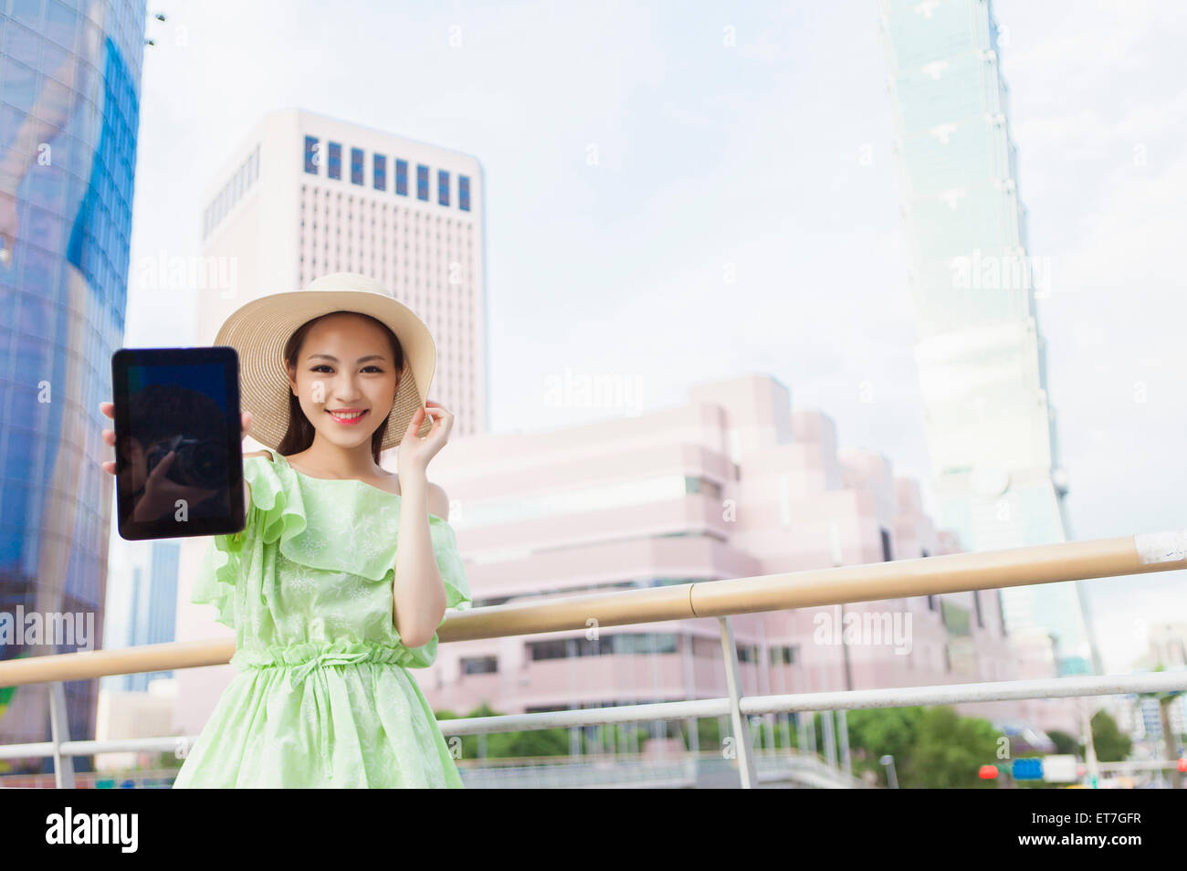 Young woman holding touchpad and smiling at the camera Stock Photo - Alamy