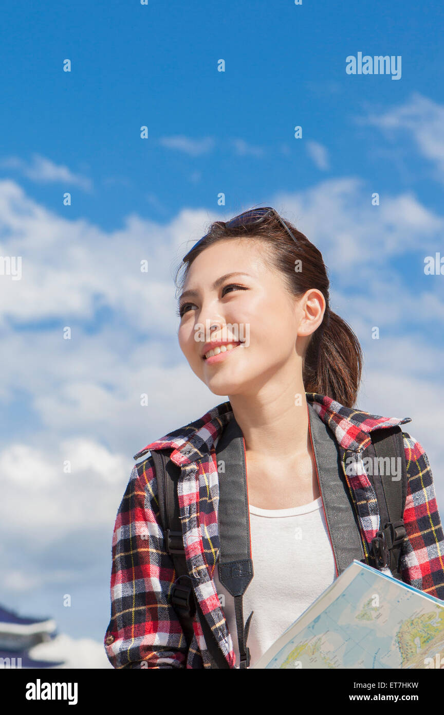 Young woman holding a map and looking away with smile Stock Photo - Alamy