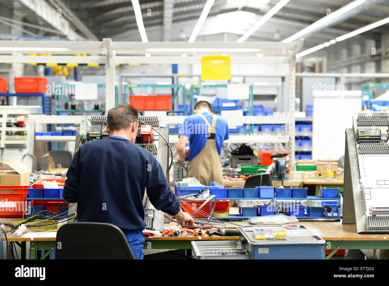 Workers in a switchboard construction factory Stock Photo - Alamy