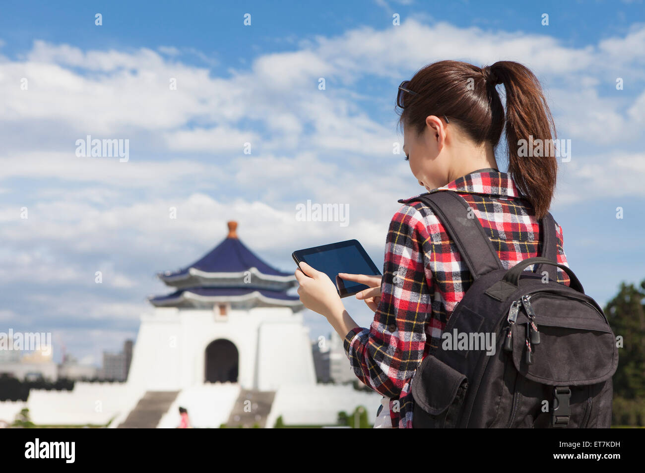 Young woman holding touch pad and looking down Stock Photo - Alamy