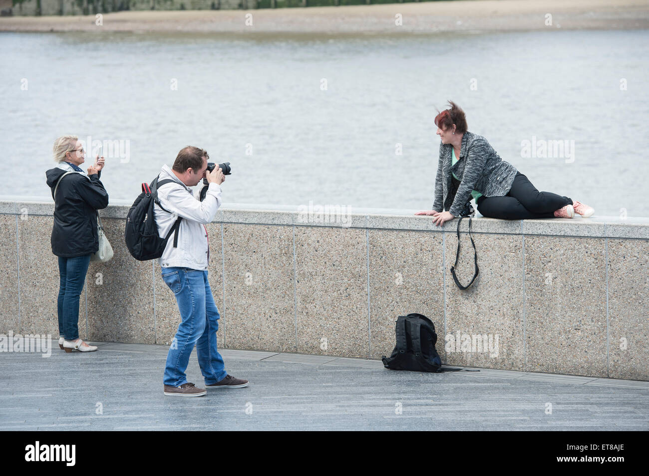Tourist posing for a photograph by the River Thames in London Stock ...