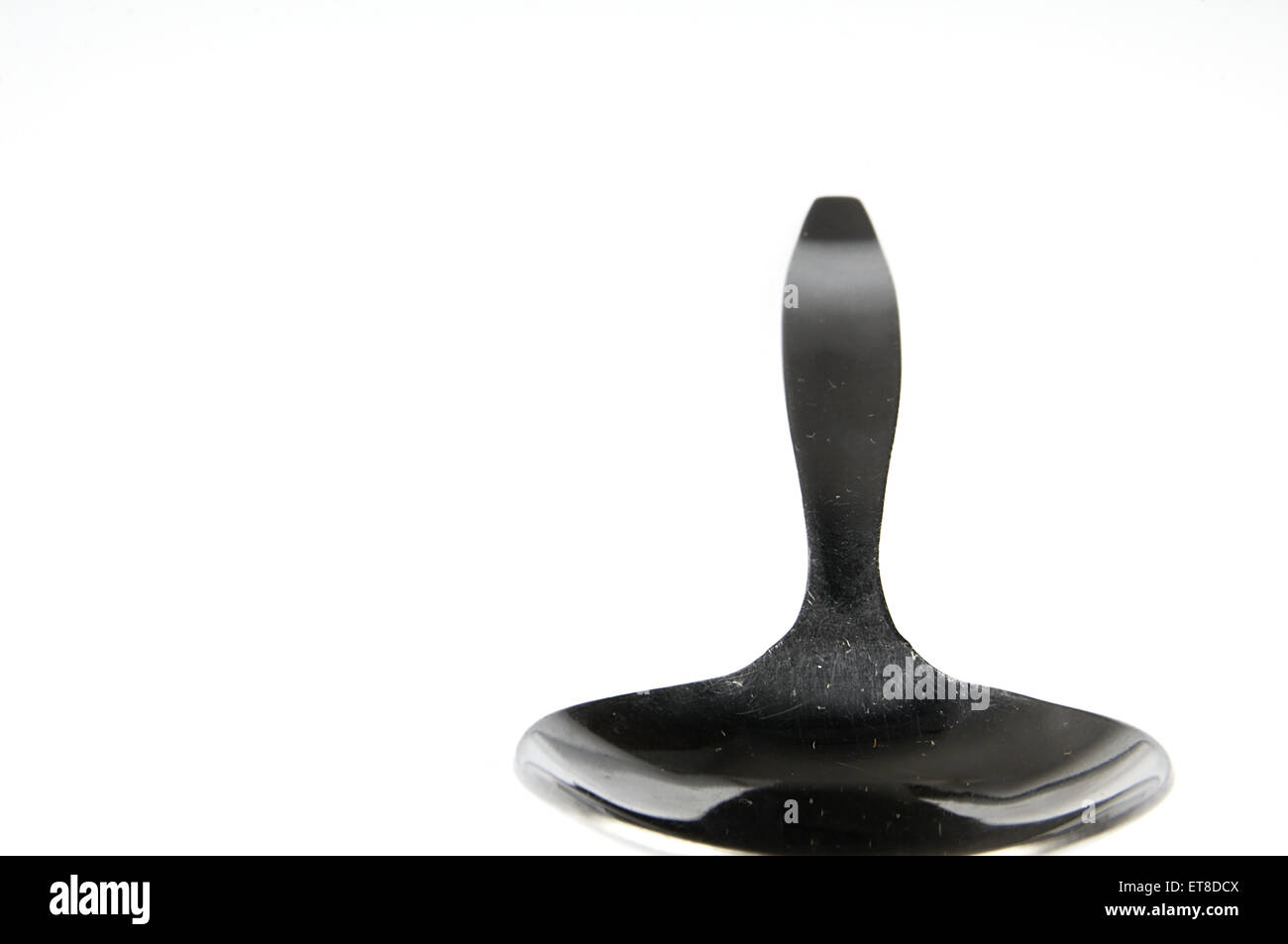 Metal spoon lying on the kitchen, white table Stock Photo - Alamy