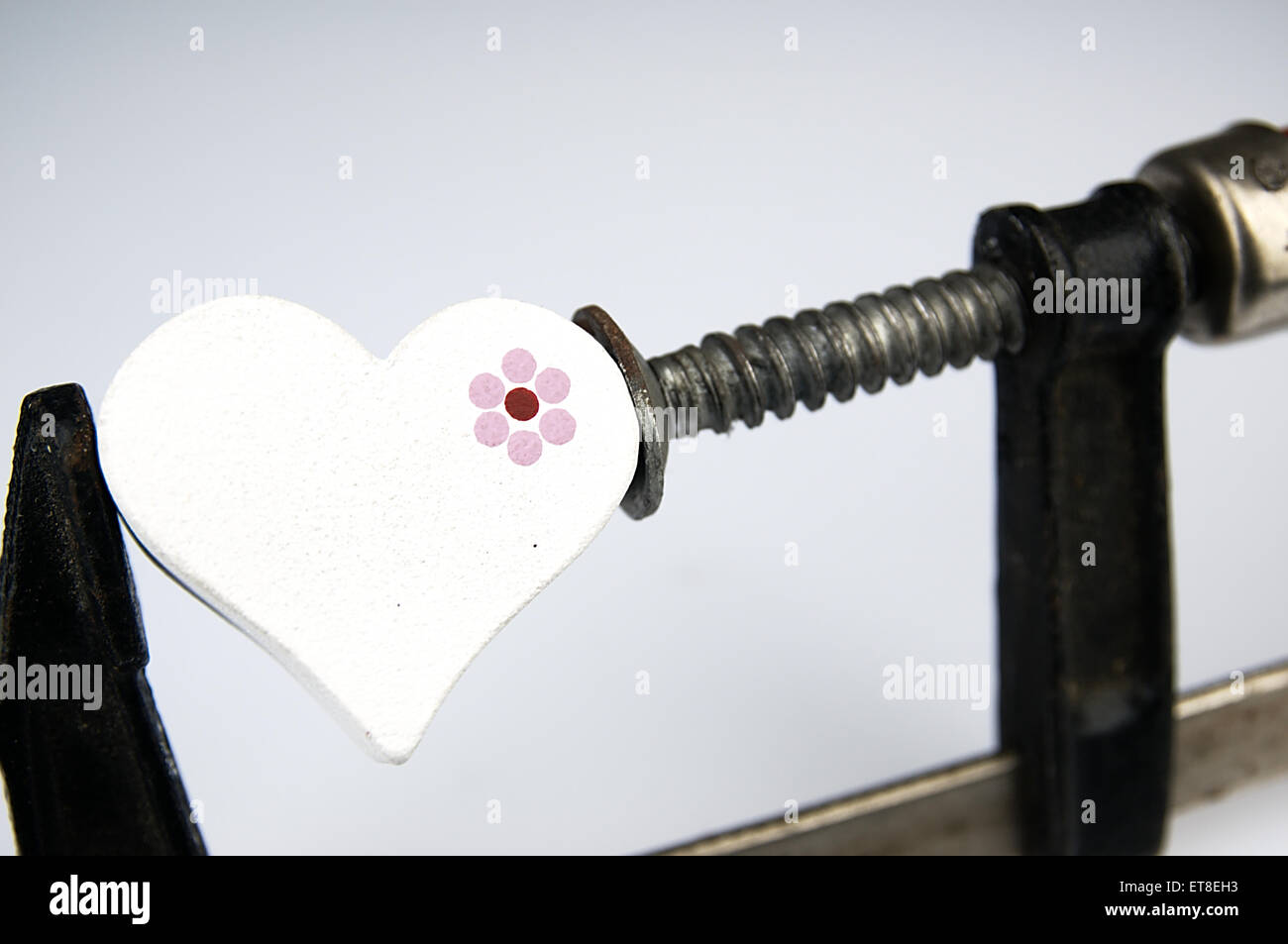 White heart and carpenter clamp. The idea for the display of a heart ...