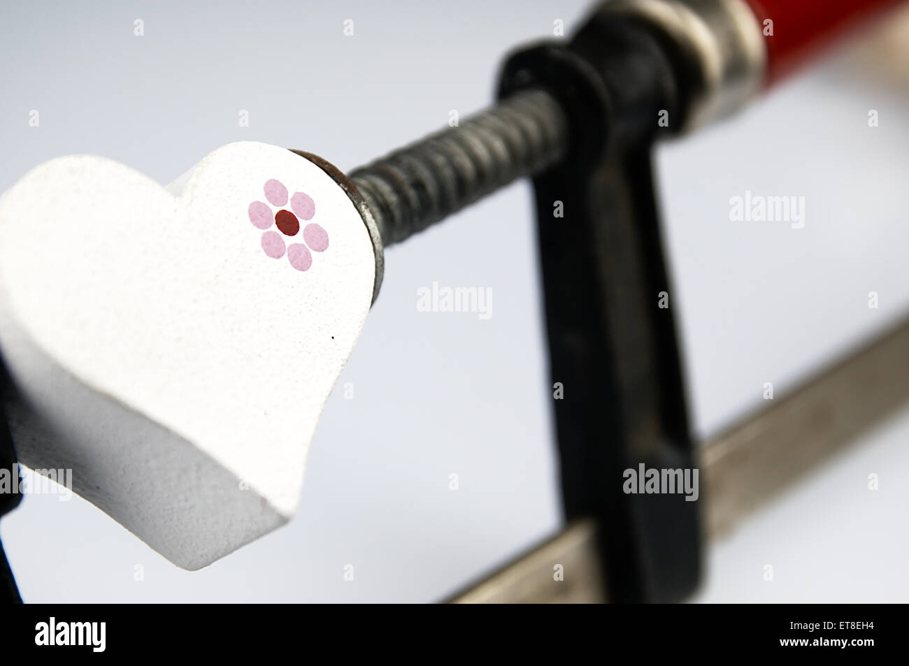 White heart and carpenter clamp. The idea for the display of a heart ...