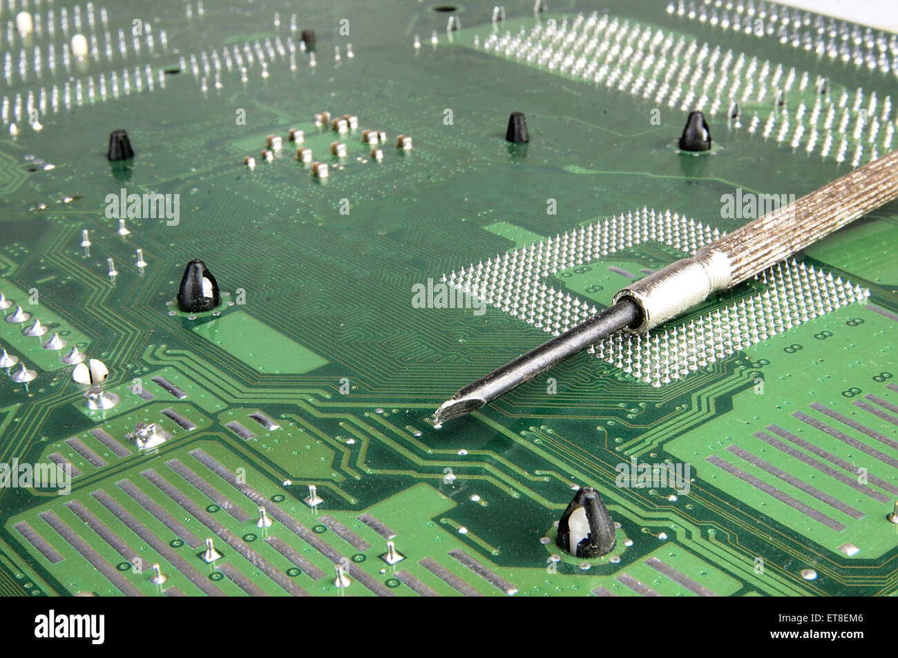 The surface of the old motherboard and small metal Screwdriver Stock ...