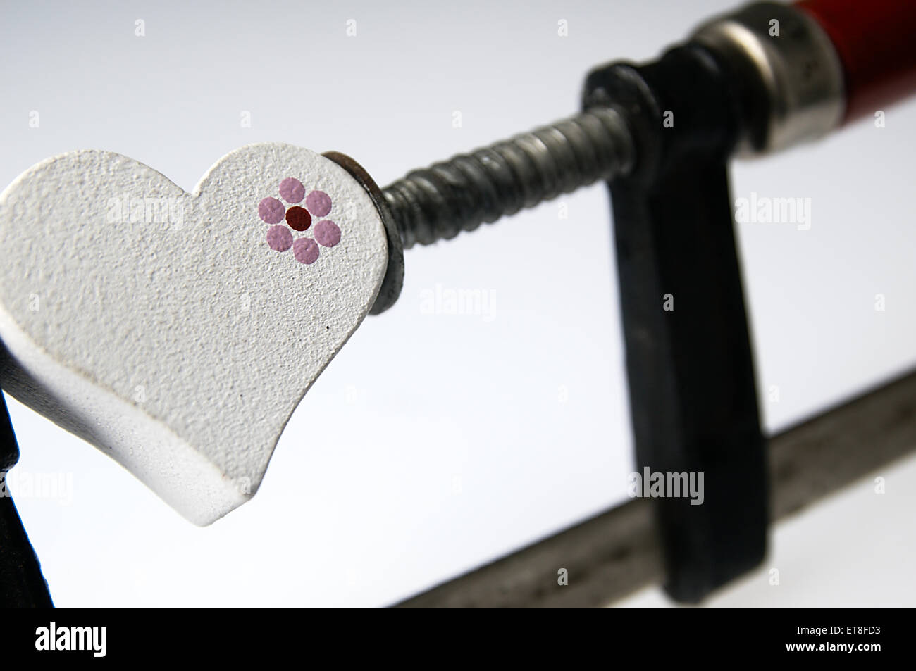White heart and carpenter clamp. The idea for the display of a heart ...