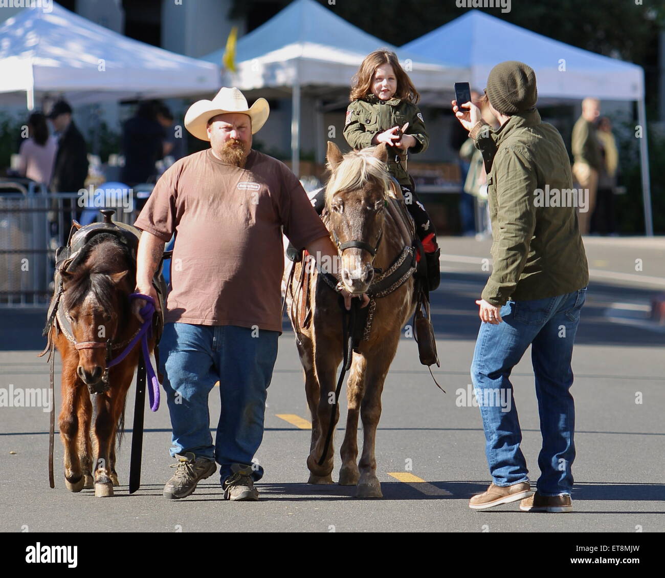 Rodger Berman takes his son, Skyler to ride a pony at the Farmers ...