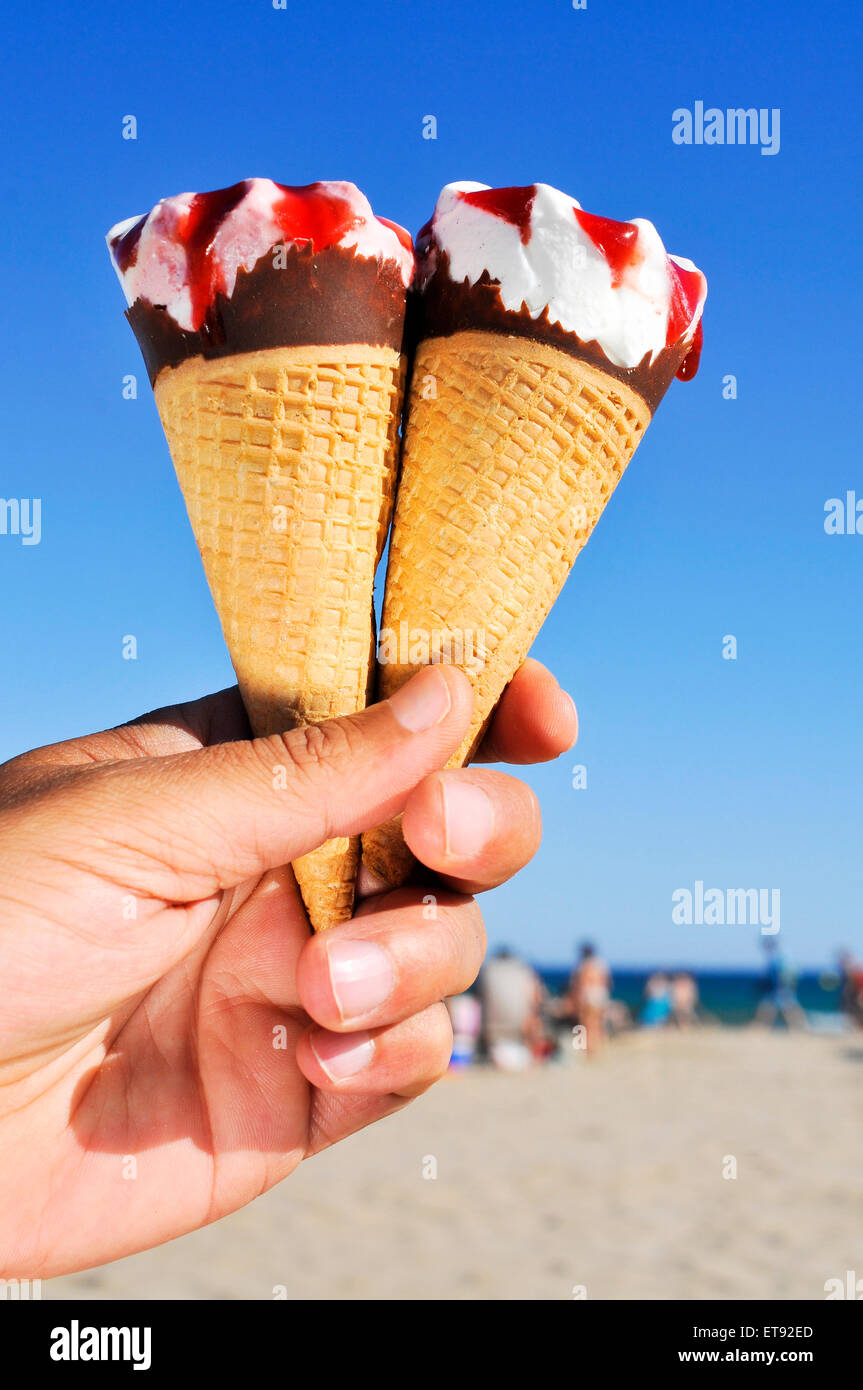 closeup of a young caucasian man with some ice cream cones of different ...