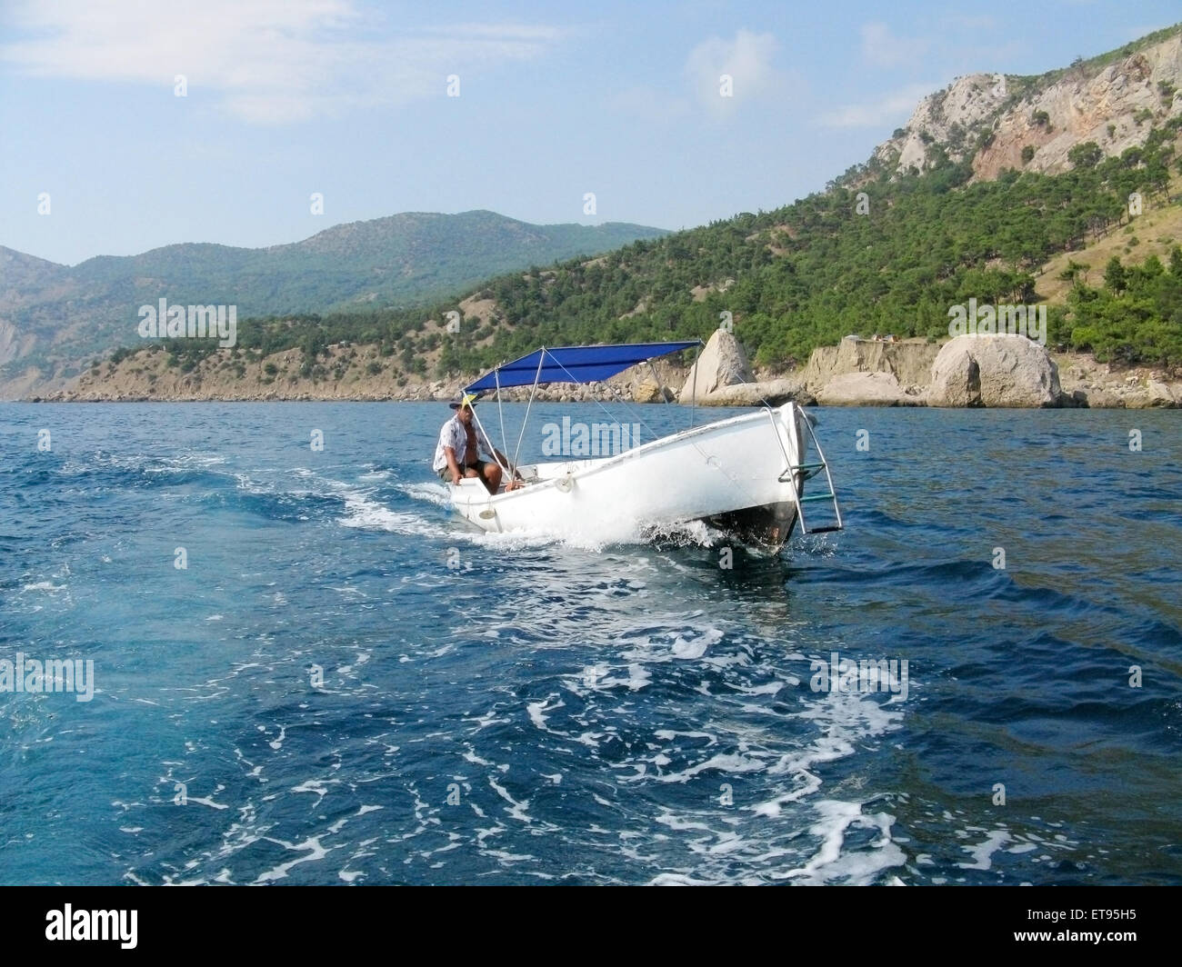 Man driving a boat in the sea Stock Photo - Alamy