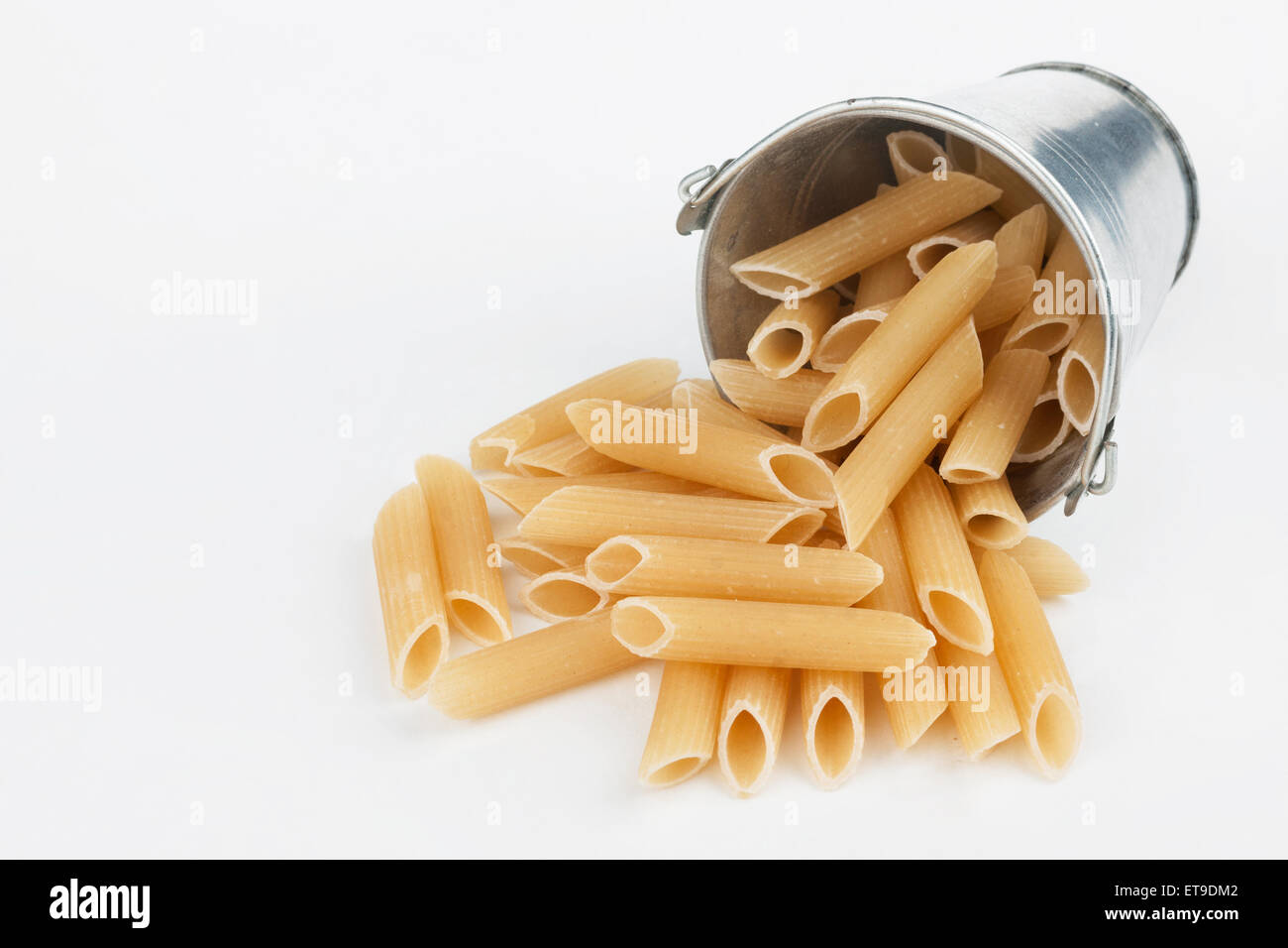 Pasta spilling out of bucket, on a white background Stock Photo - Alamy