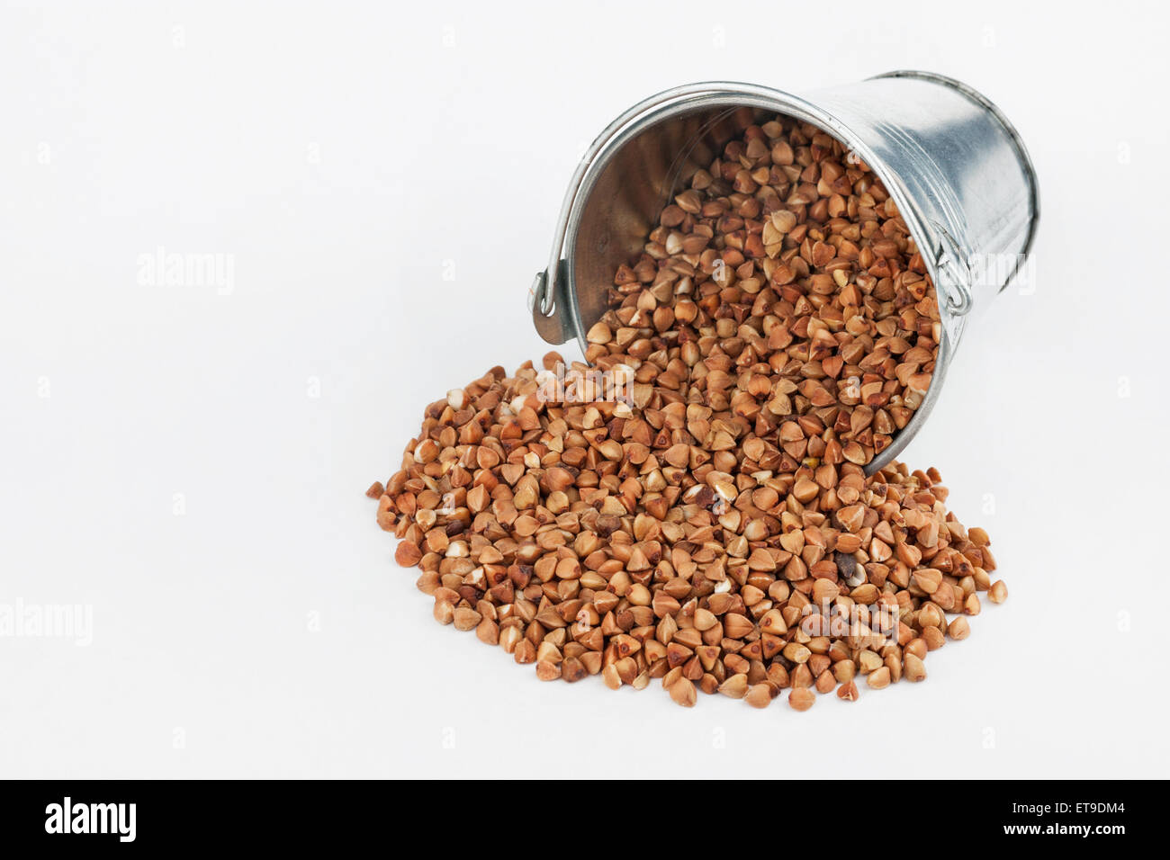 Buckwheat grains spilling out of bucket, on a white background Stock ...