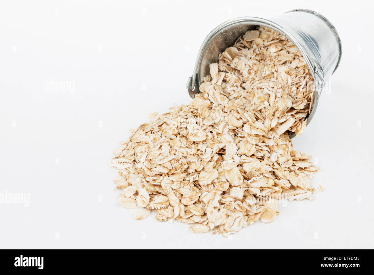 Oat flakes spilling out of bucket, on a white background Stock Photo ...