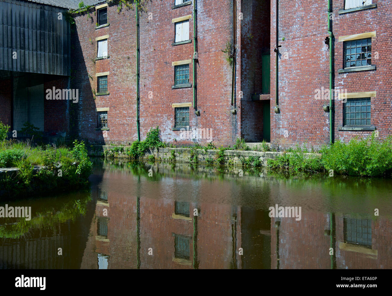 Derelict factory reflected in the Leeds and Liverpool, Canal, Saltaire ...