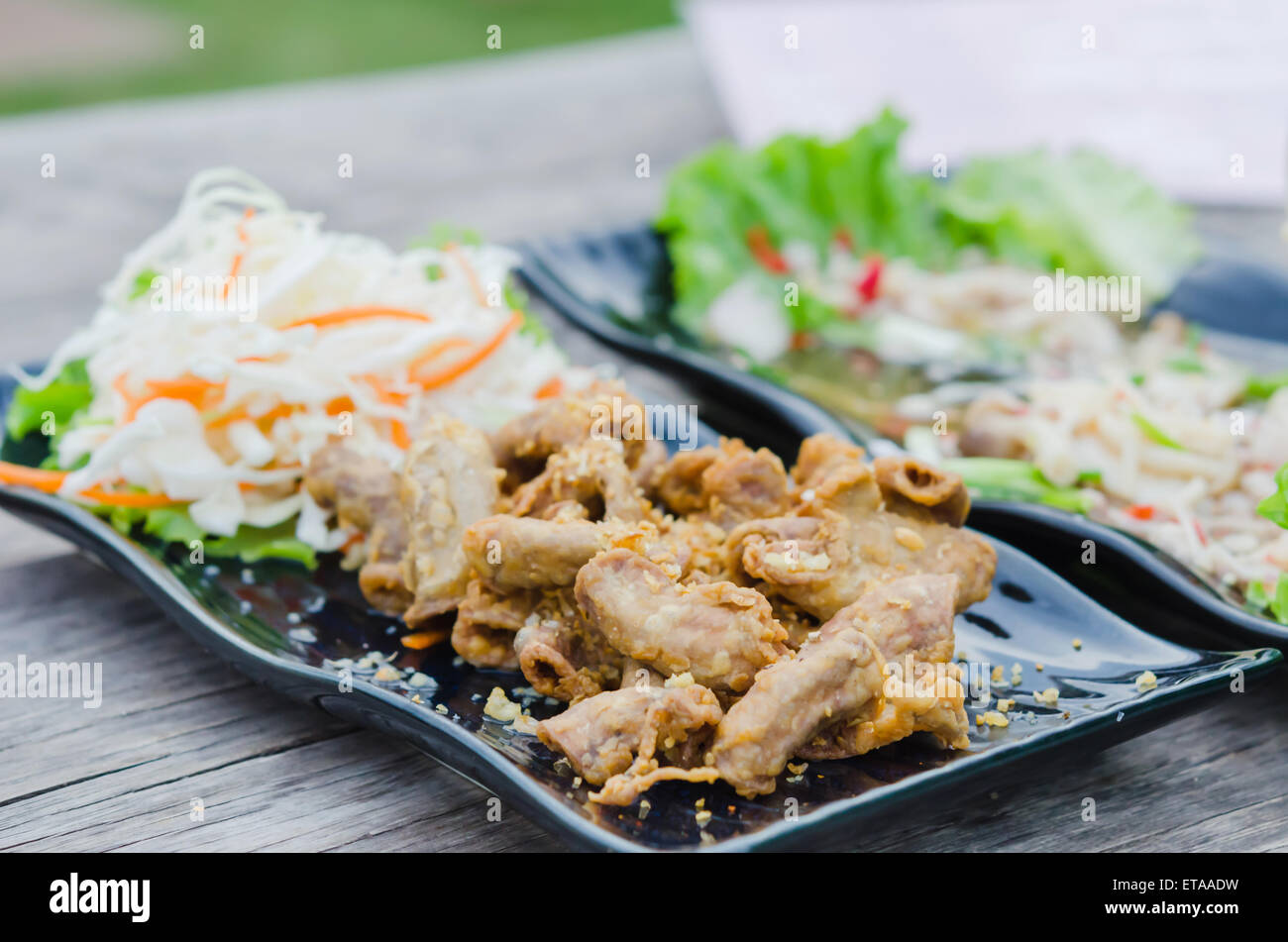 pork chitterlings fried served with fresh vegetable on dish Stock Photo ...