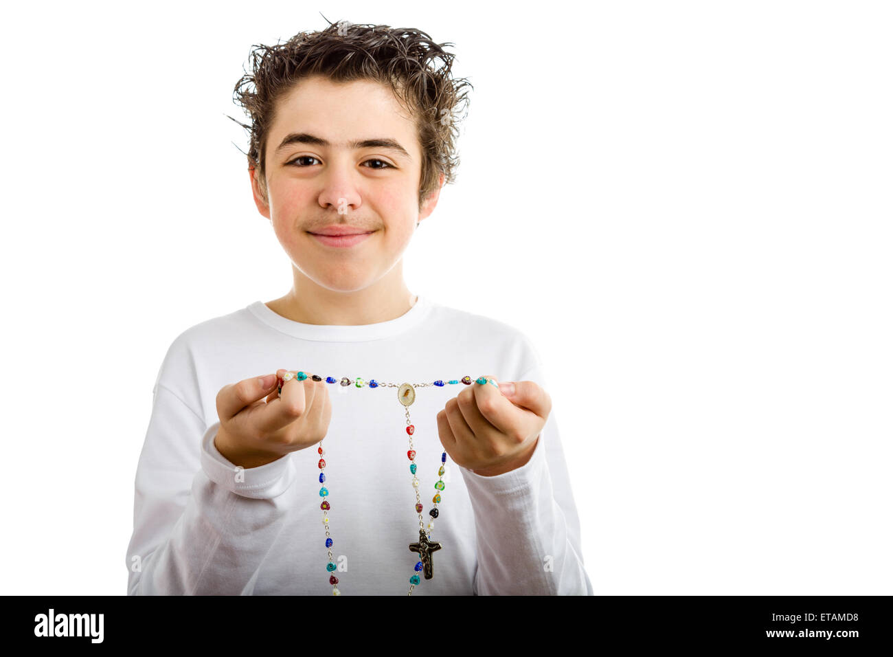 A Caucasian boy holds Rosary beads with both hands: Rosary includes a ...