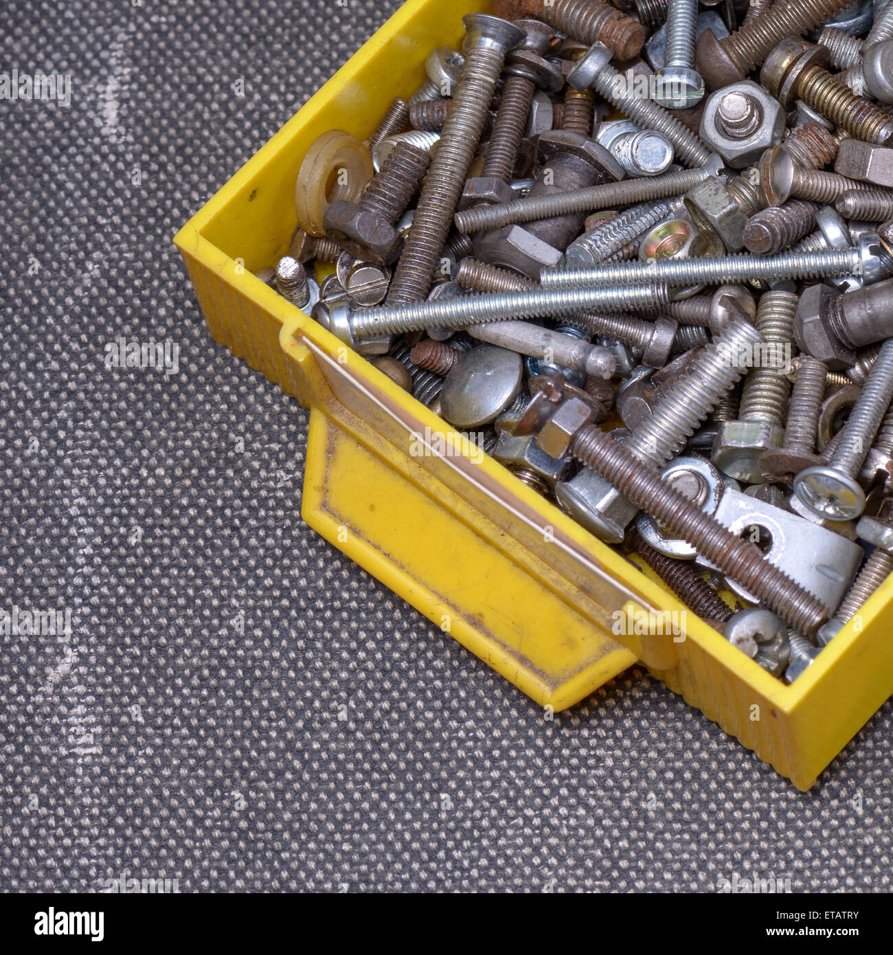 Yellow old box with several screws Stock Photo - Alamy