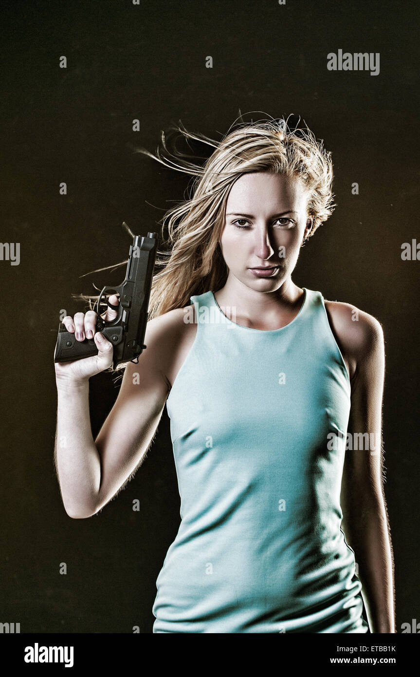 Dangerous young woman holding a gun Stock Photo - Alamy