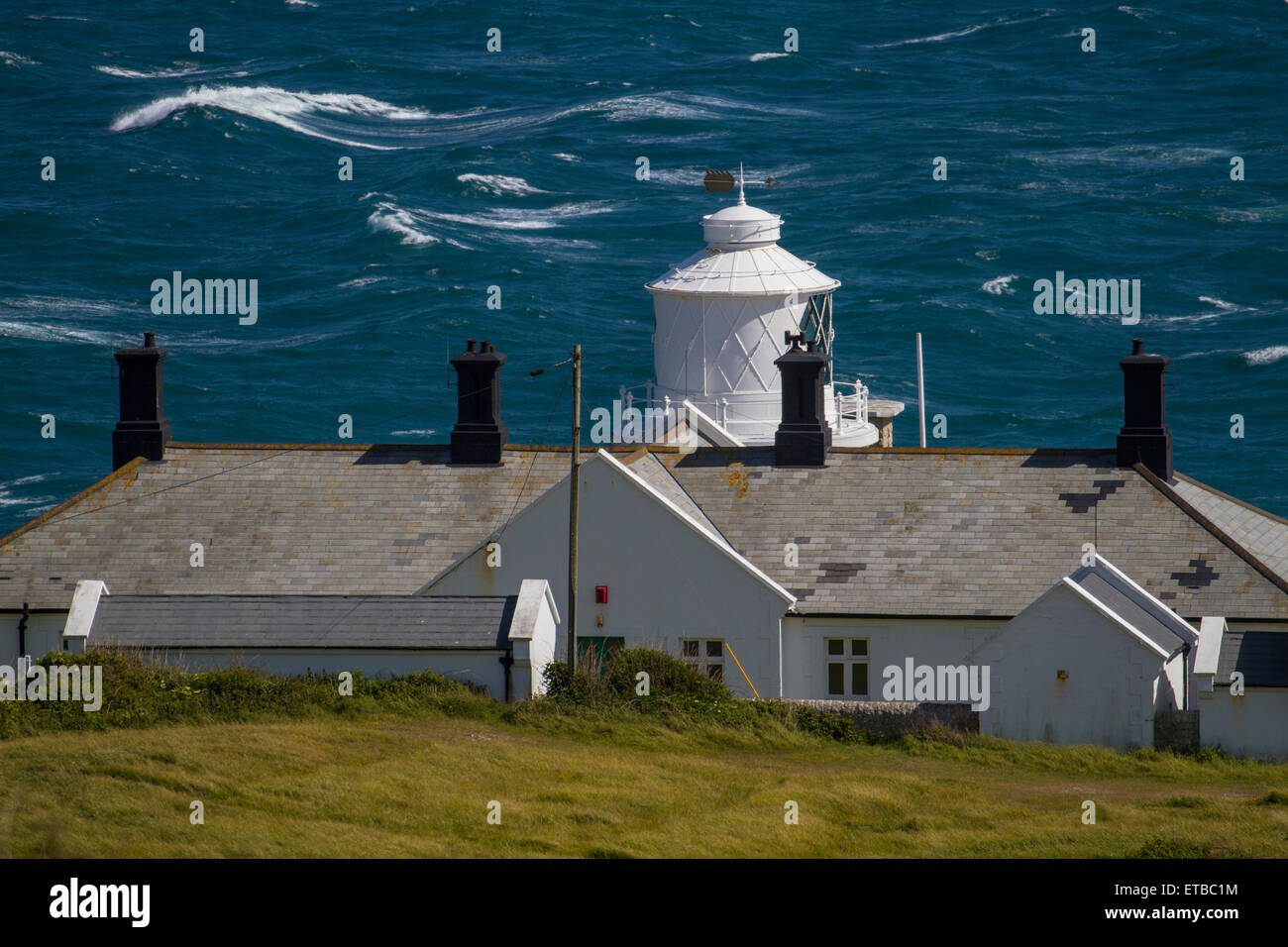 lighthouse overlooking rough sea on sunny day Stock Photo - Alamy