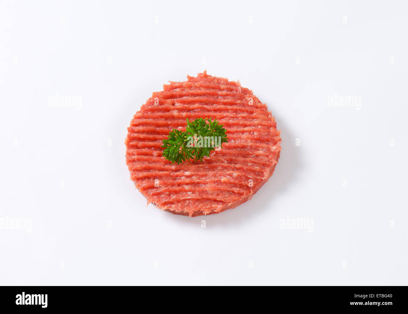 raw hamburger patty with parsley on white background Stock Photo - Alamy