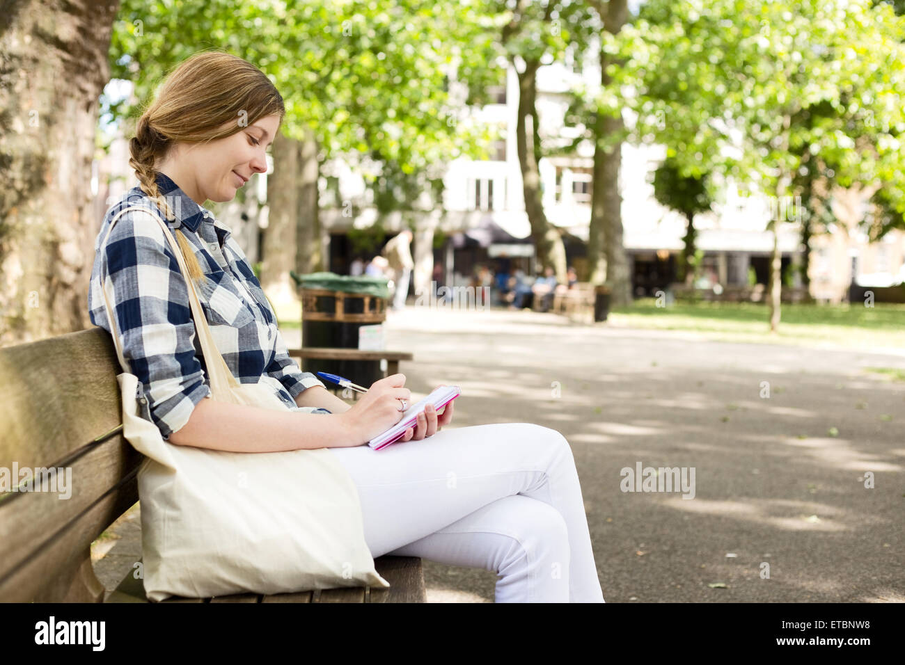 young woman writing notes in the park Stock Photo - Alamy