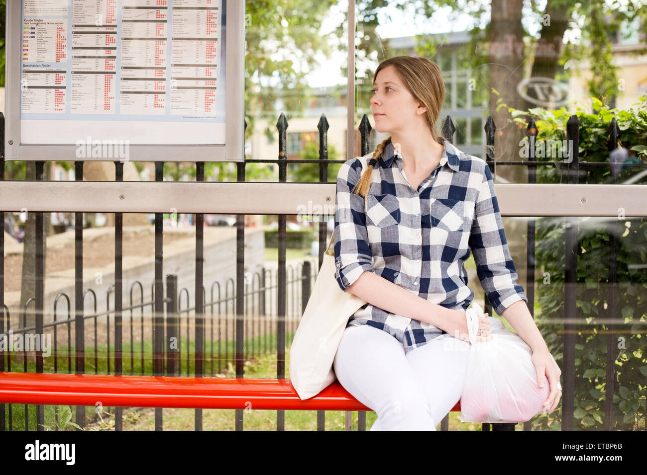 young woman sitting at the bus stop Stock Photo - Alamy